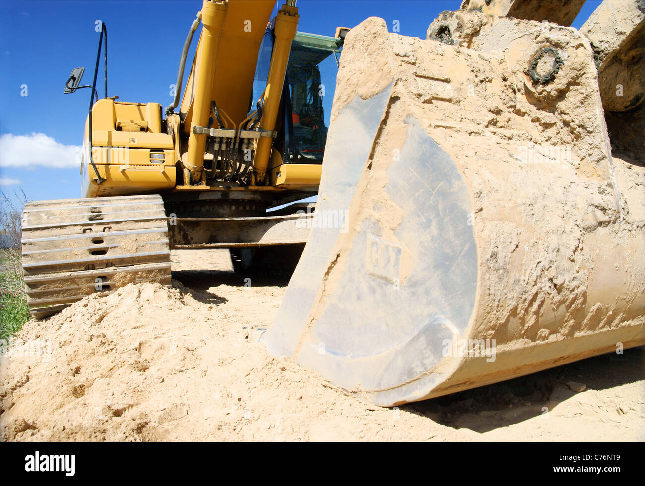 yellow excavator, digger on blue sky Stock Photo - Alamy