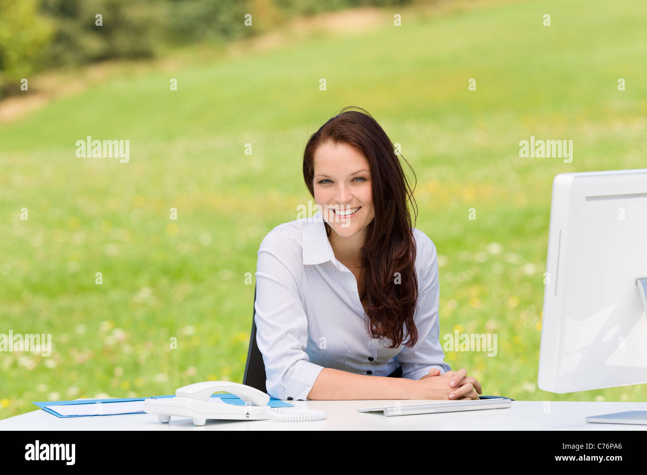 Young businesswoman in nature attractive smiling sitting behind ...