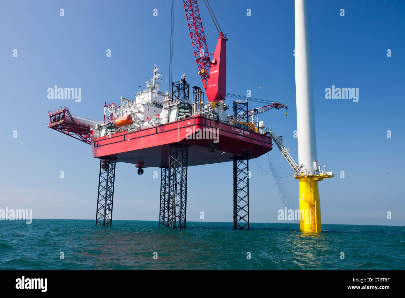 A jack up barge lifts a nacelle onto a wind turbine tower at the Walney ...