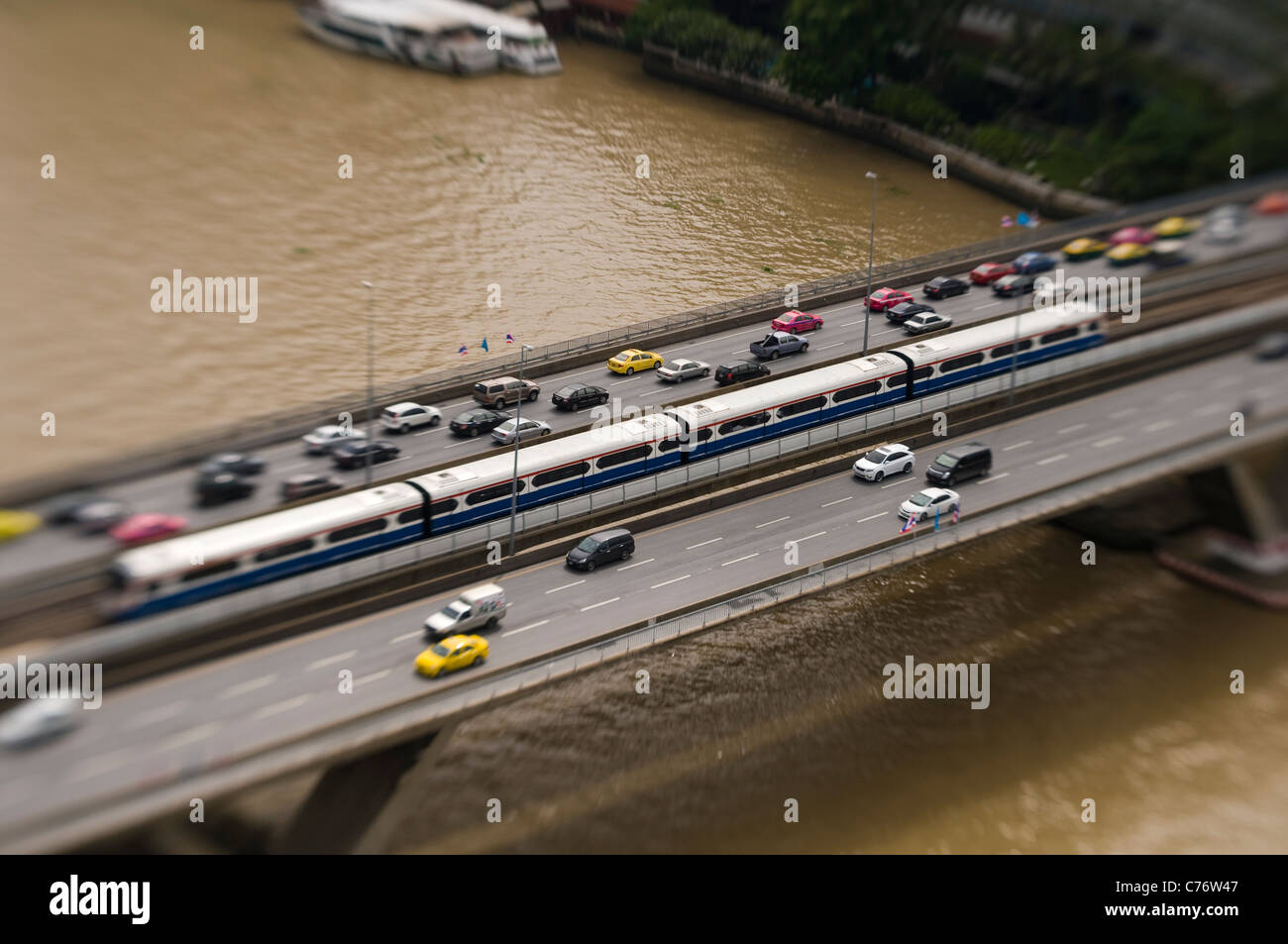 A BTS skytrain and many cars on the Taksin bridge in Bangkok. view from ...