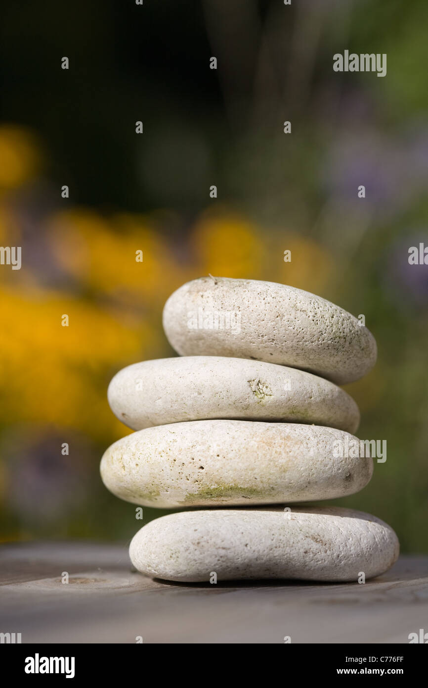 Stack of four stones on table in garden Stock Photo - Alamy