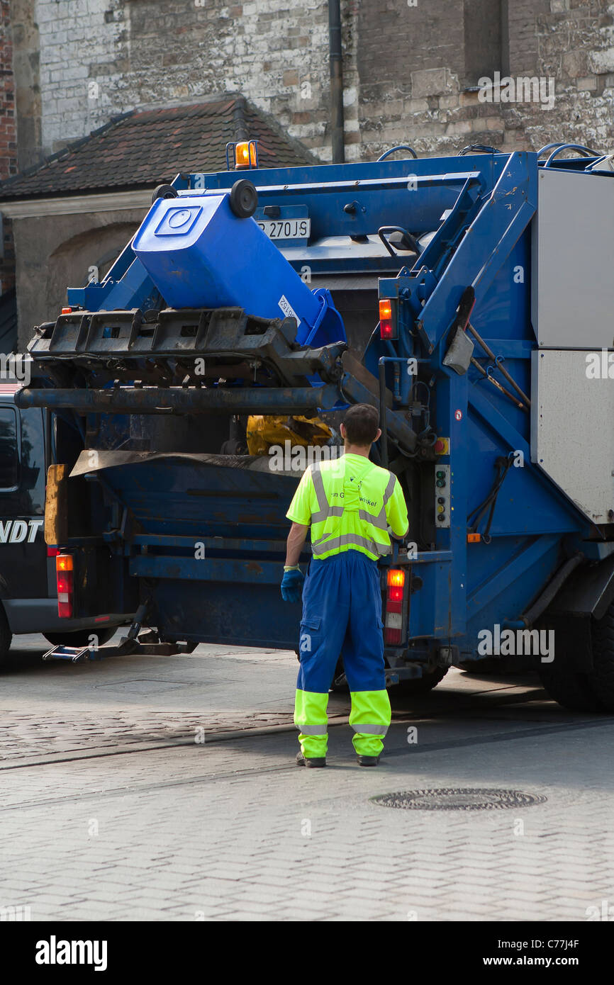 Cleaner worker during work at street with rubbish collection lorry ...