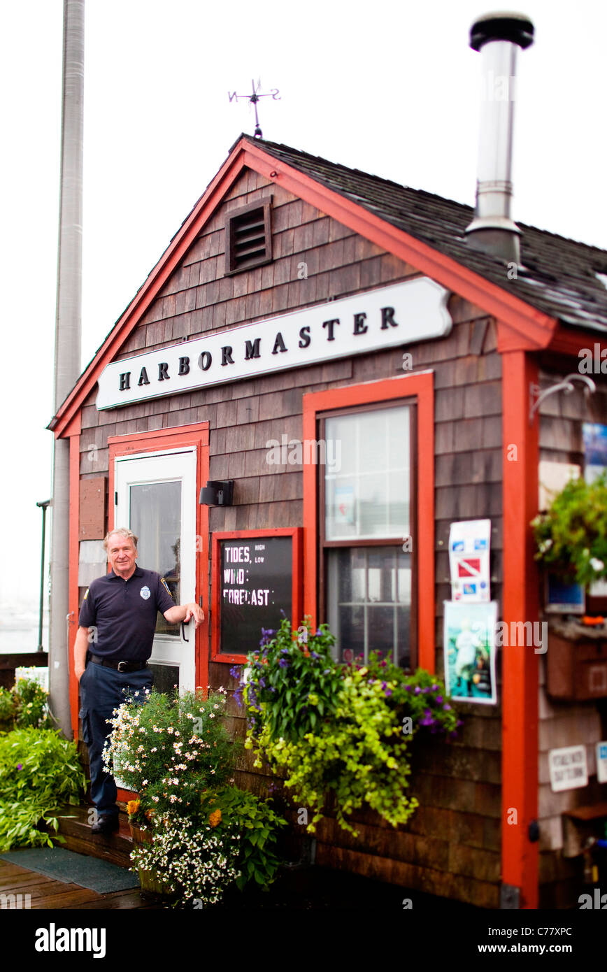 A portrait of a man standing in front of a quant building on the harbor ...
