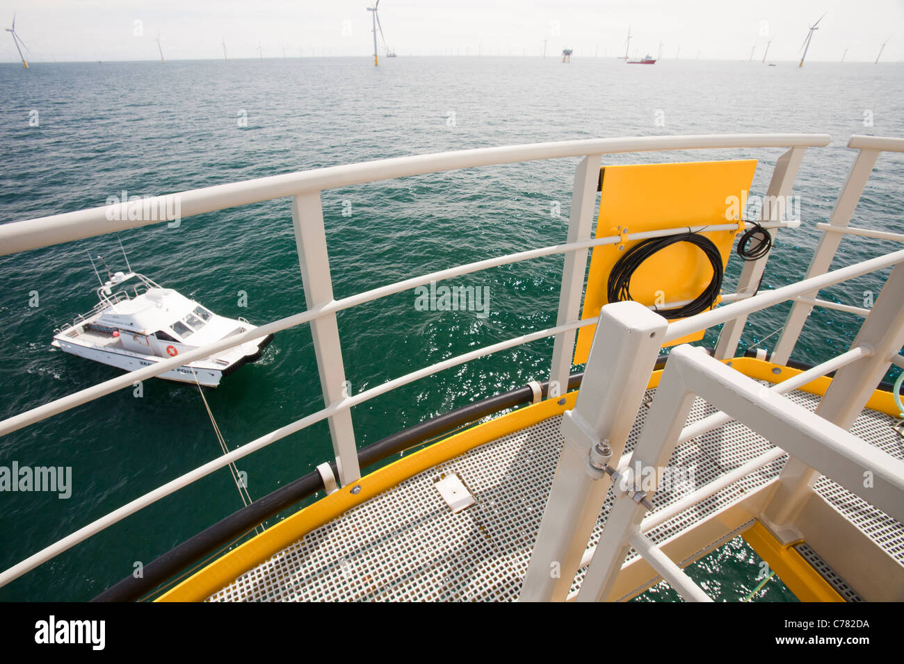 A crew transfer vessel moored next to a wind turbine at the Walney ...
