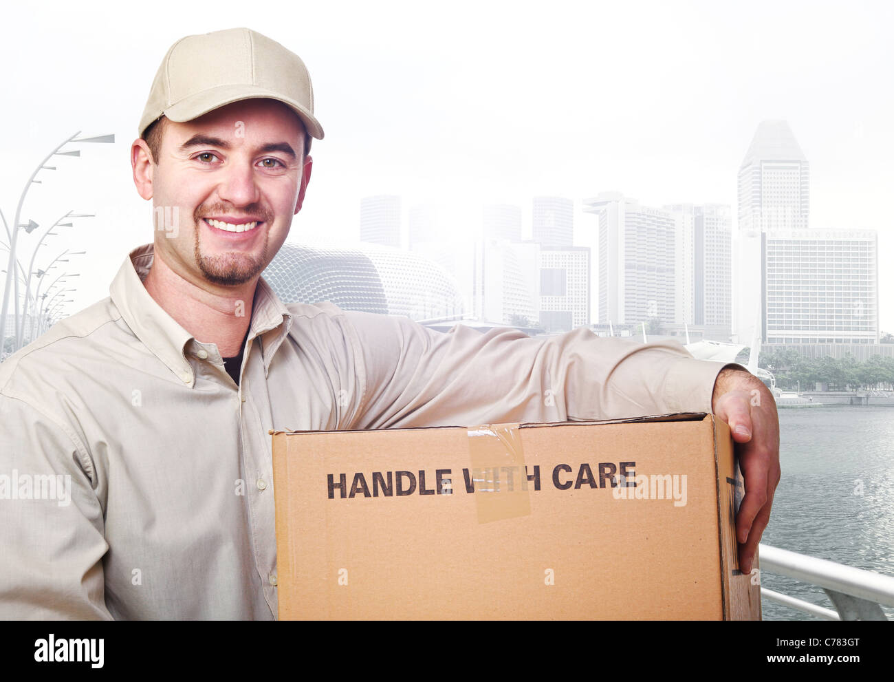 smiling delivery man and modern town background Stock Photo - Alamy