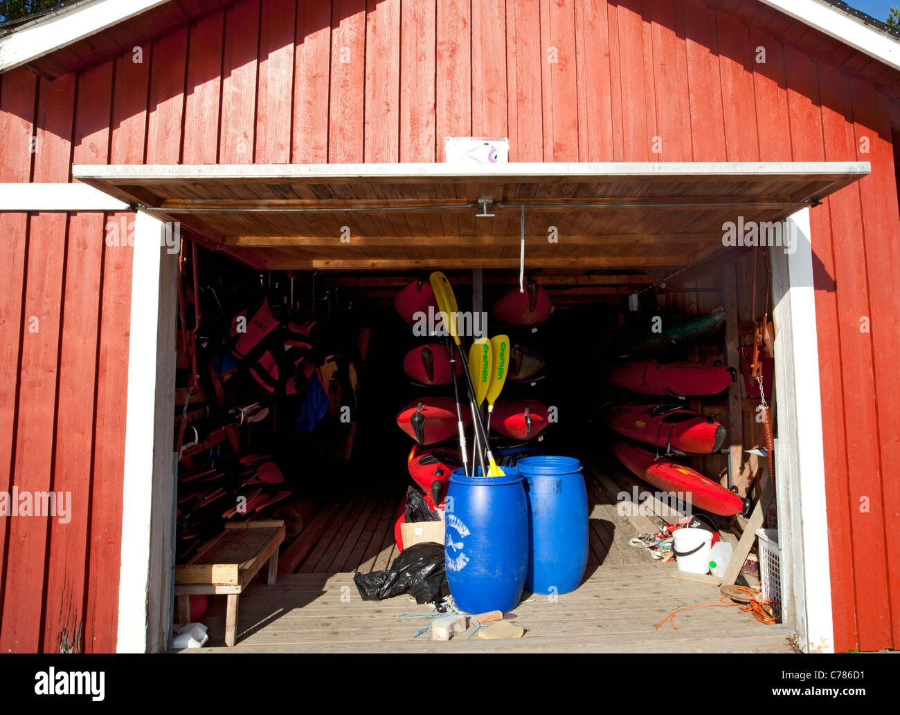 Inventory view of kayaking gear and kayaks inside boat house , Finland ...