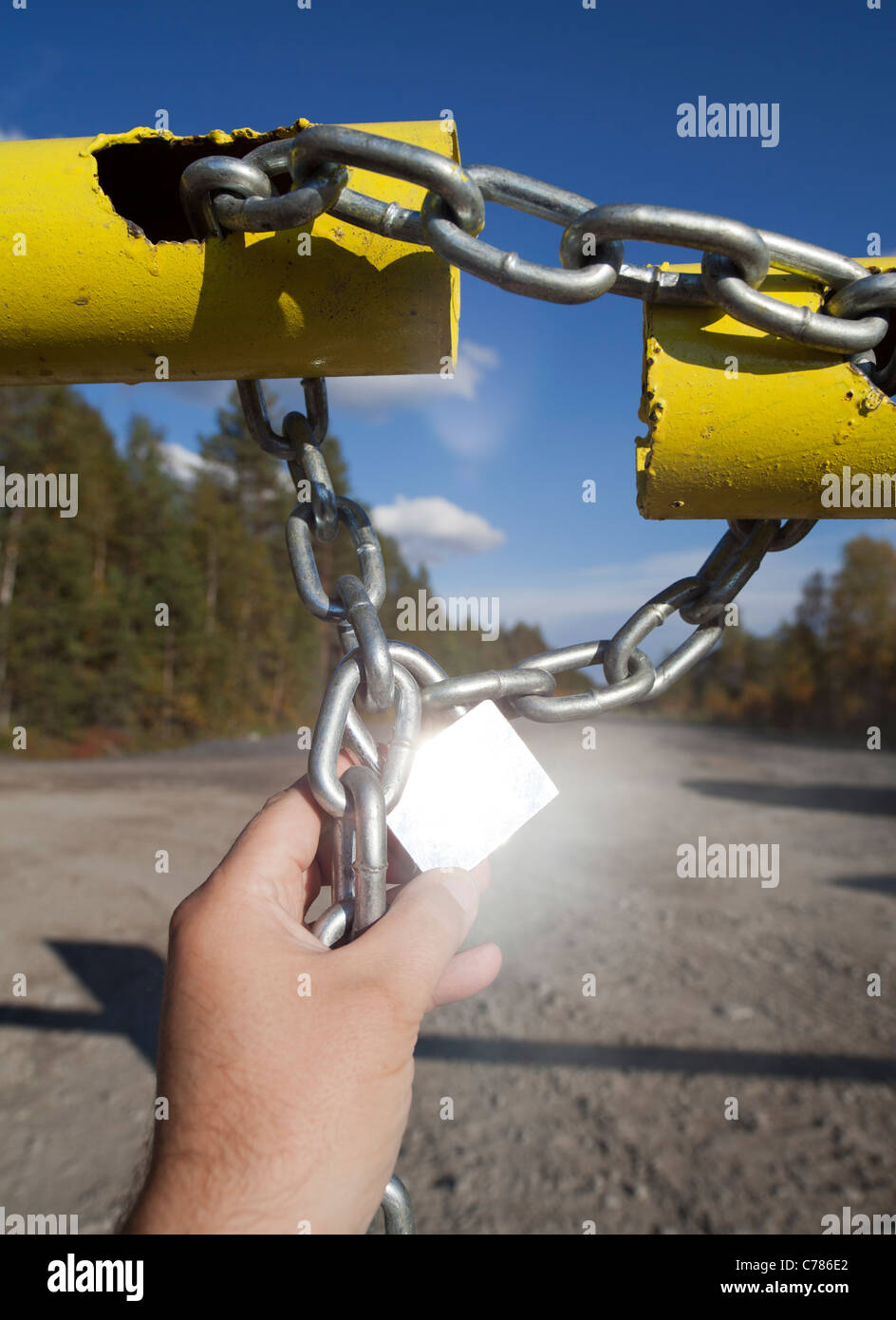 Hand holding isolated shiny padlock boom secured with padlock and steel ...