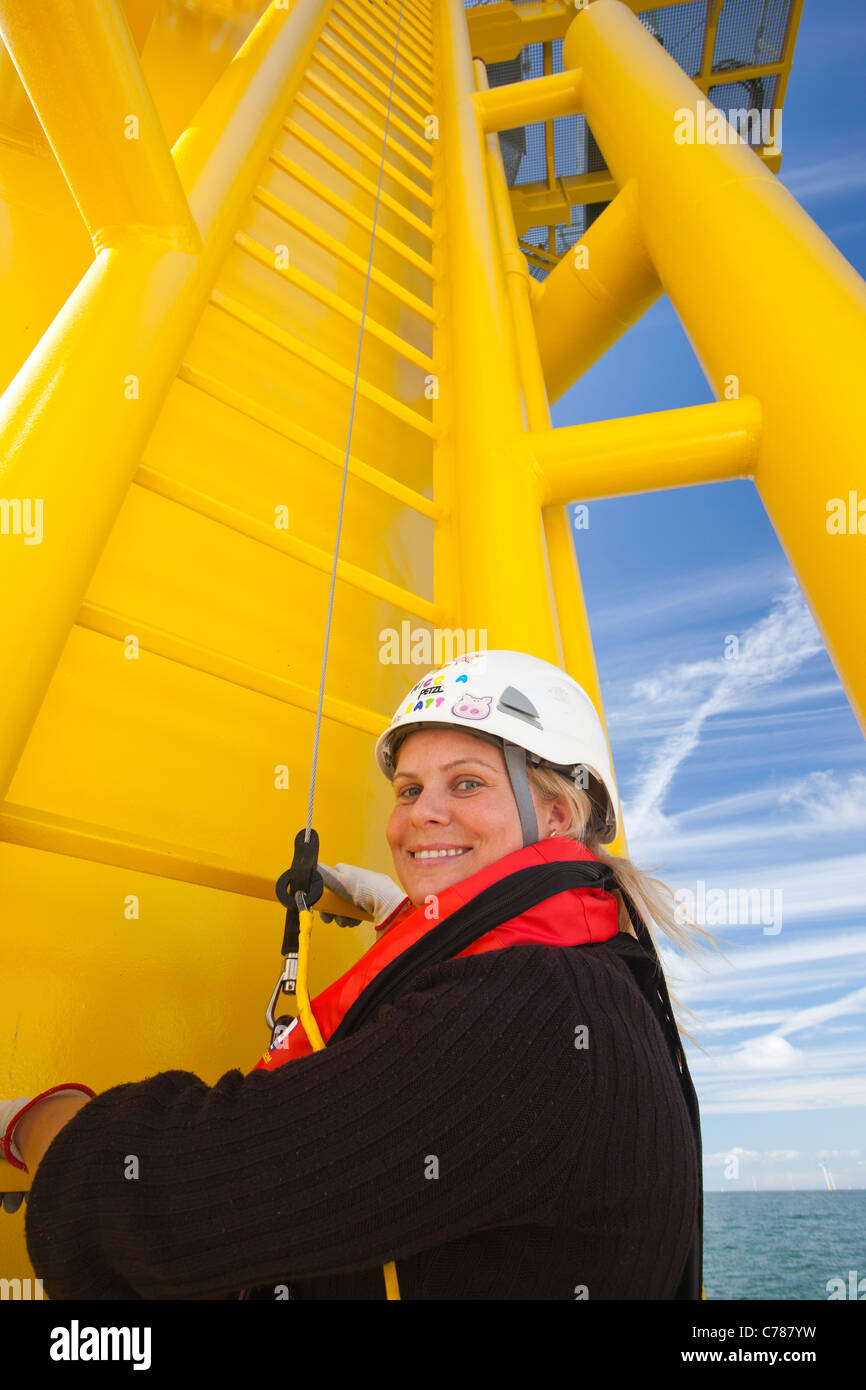 A worker climbing a wind turbine at the Walney offshore wind farm Stock ...
