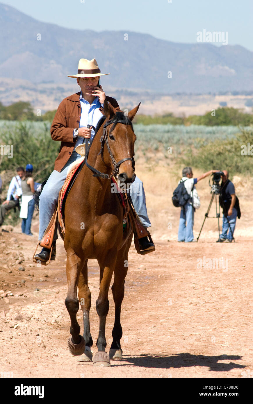 President Calderon takes a call while he rides horseback on agave ...