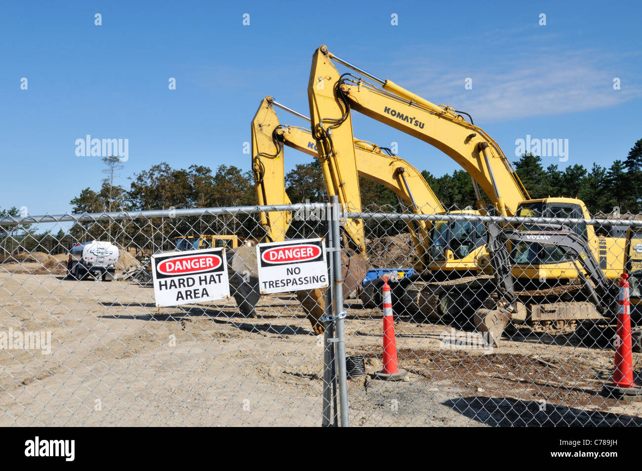 Construction site with heavy equipment surrounded by metal fence with ...