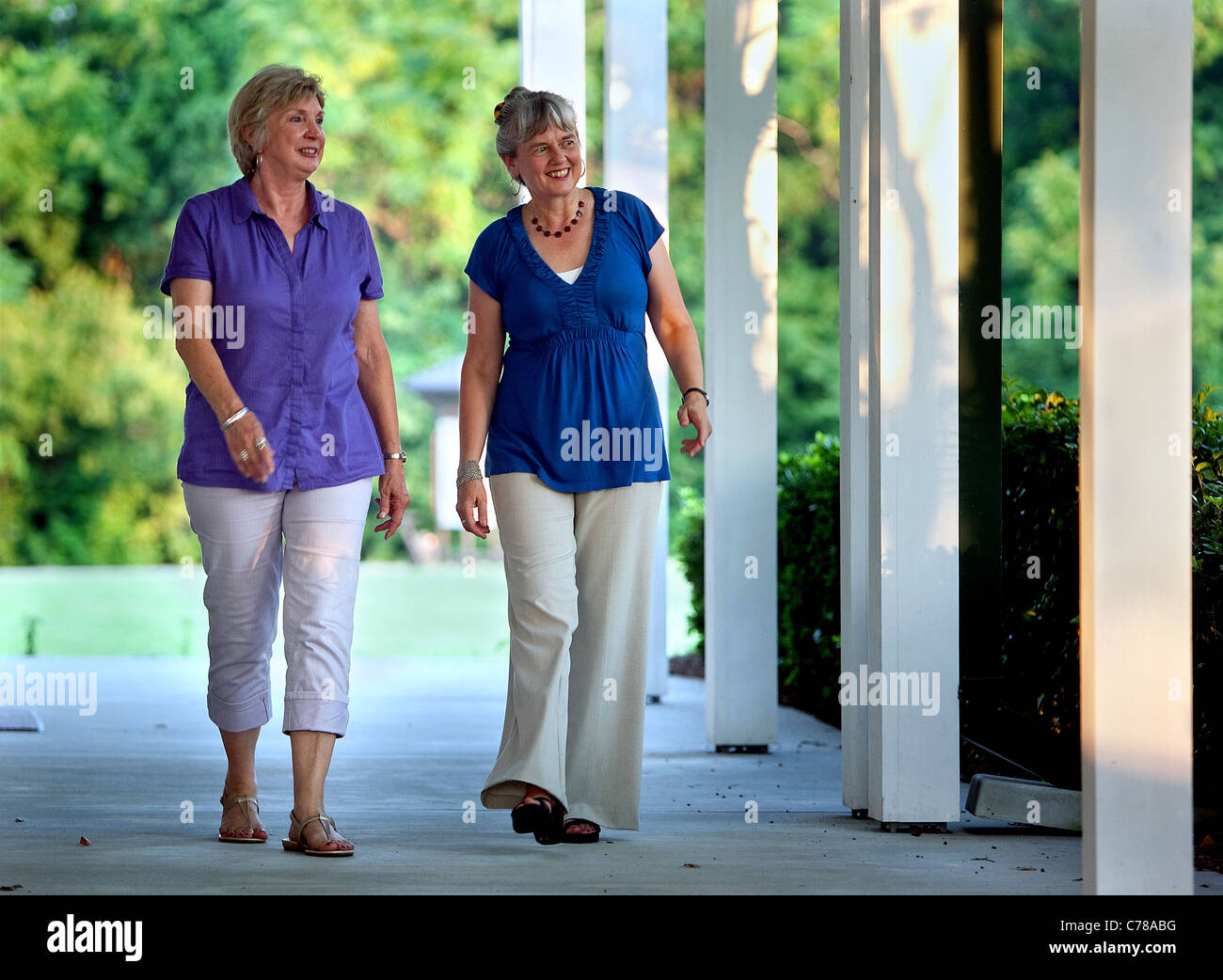Two ladies walk through a patio Stock Photo - Alamy