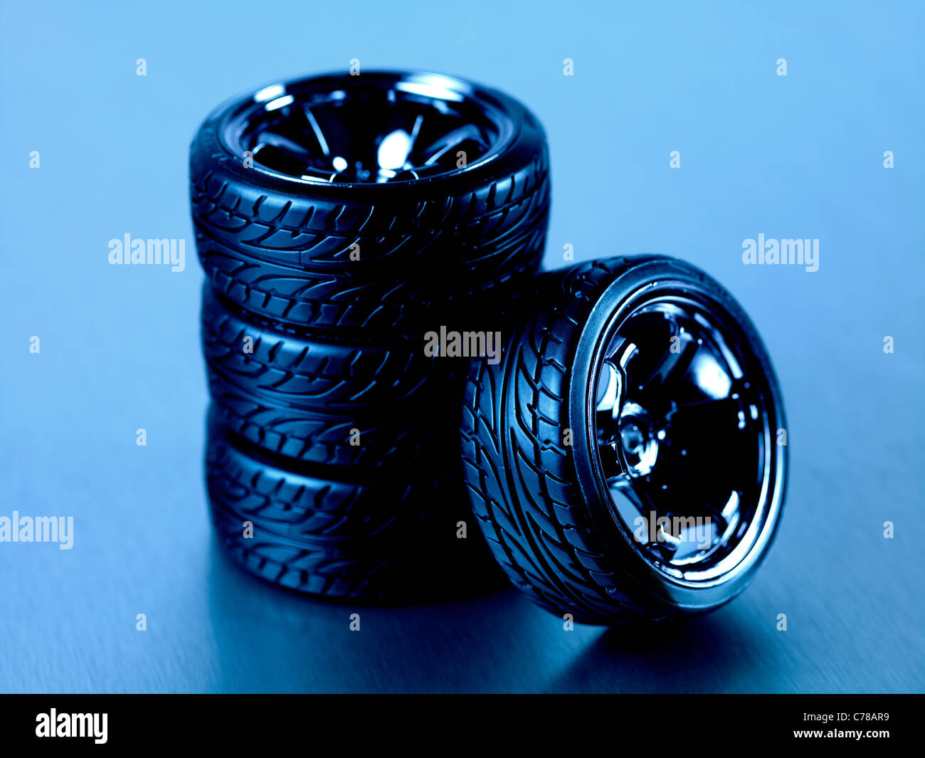 Rubber tyres with sports rims on a silver background Stock Photo - Alamy