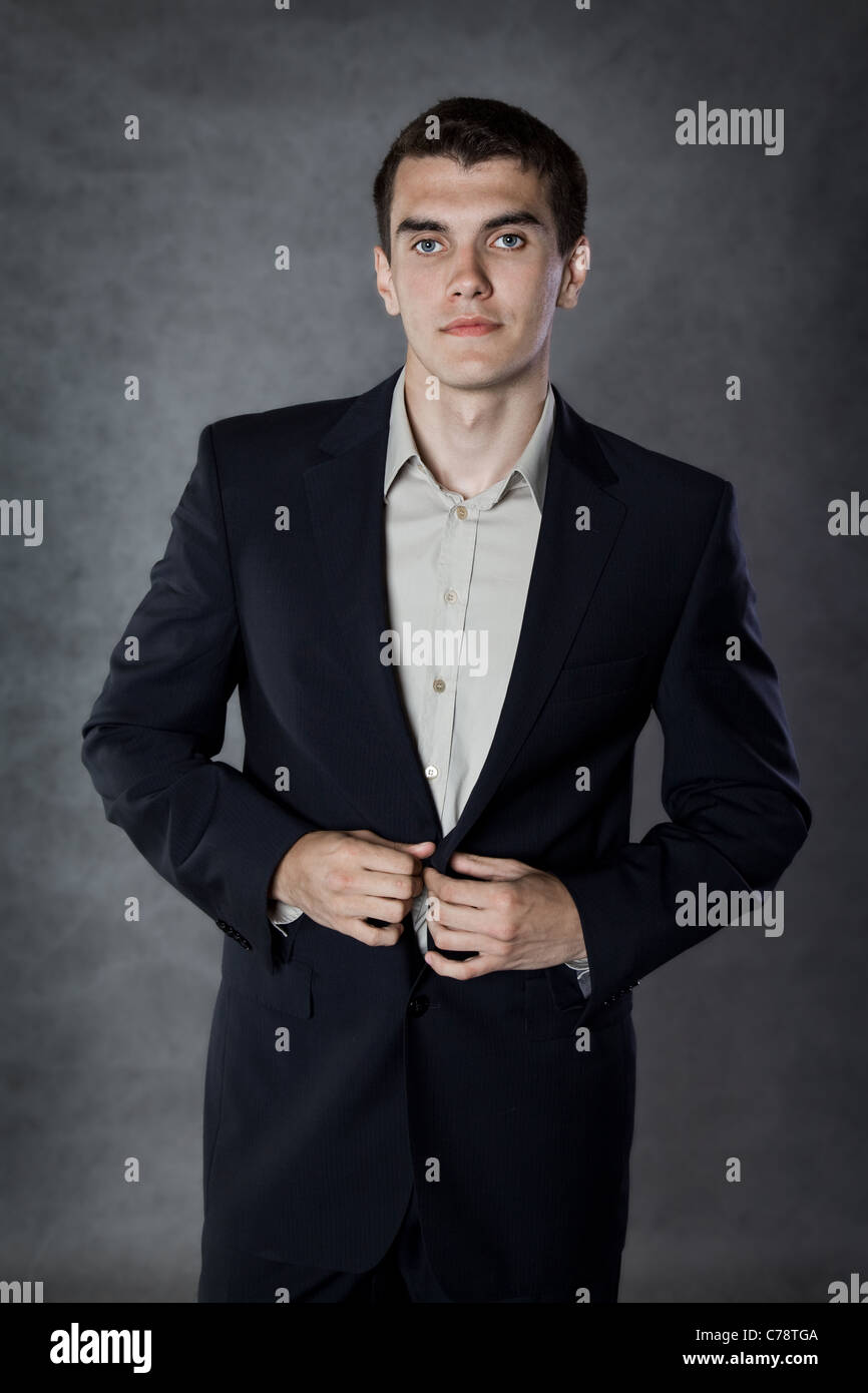 Portrait of a young man in a suit on a grey background Stock Photo - Alamy