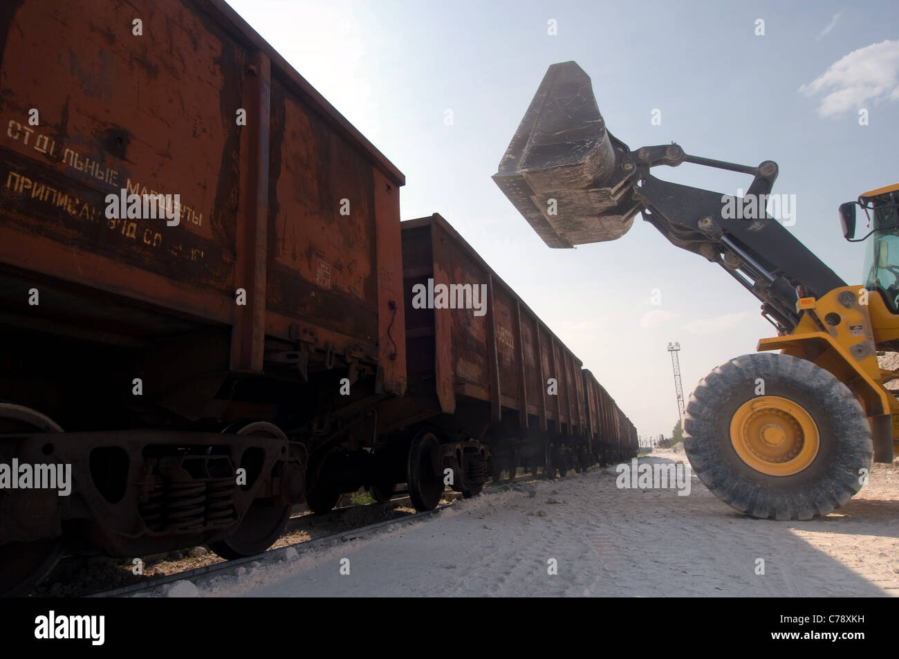 excavator loads gravel into the car of a train Stock Photo - Alamy