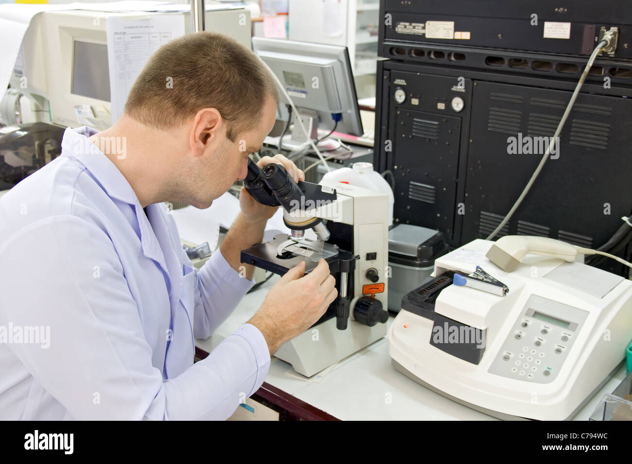 Man working with a microscope in Laboratory Stock Photo - Alamy