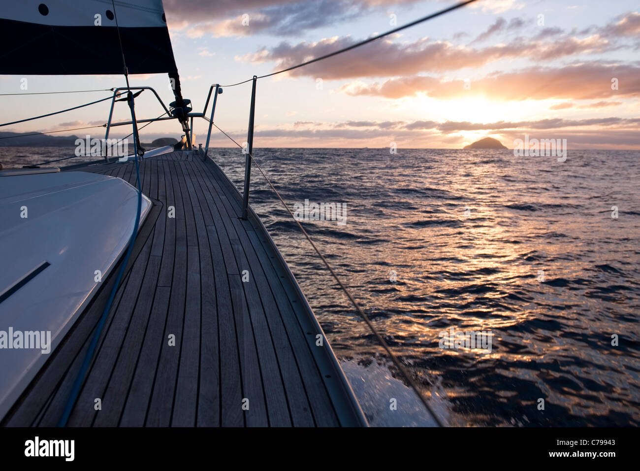 A sailing boat approaching an island at dawn Stock Photo - Alamy