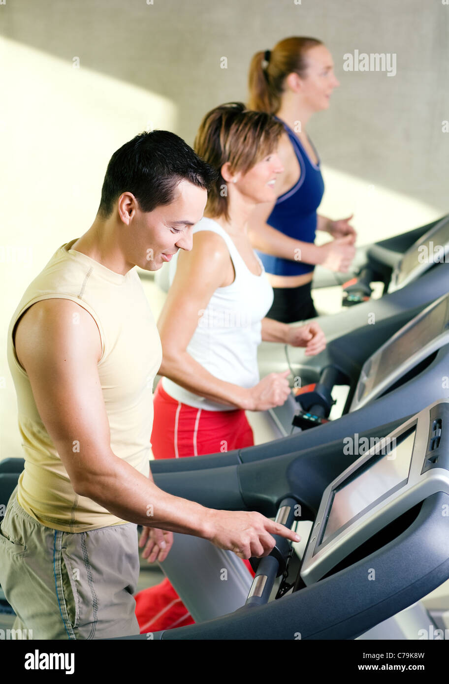 Three people on the treadmill in a gym running Stock Photo - Alamy