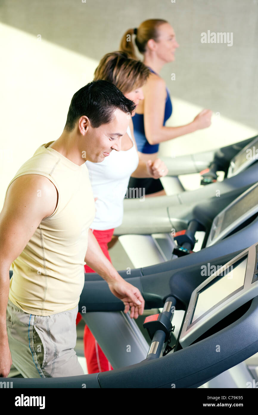 Three people on the treadmill in a gym running Stock Photo - Alamy