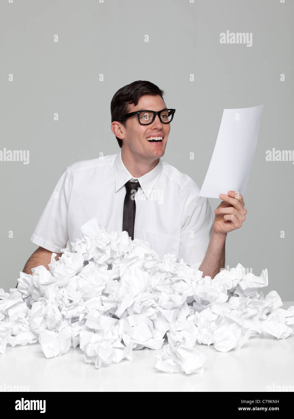 Studio portrait of young man behind stack of paper balls Stock Photo ...