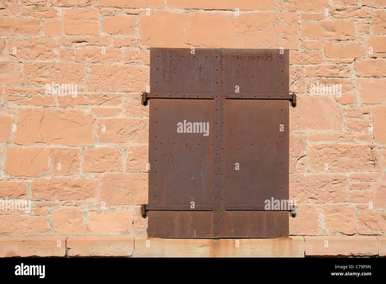 rusty metal doors in red sandstone wall Stock Photo - Alamy