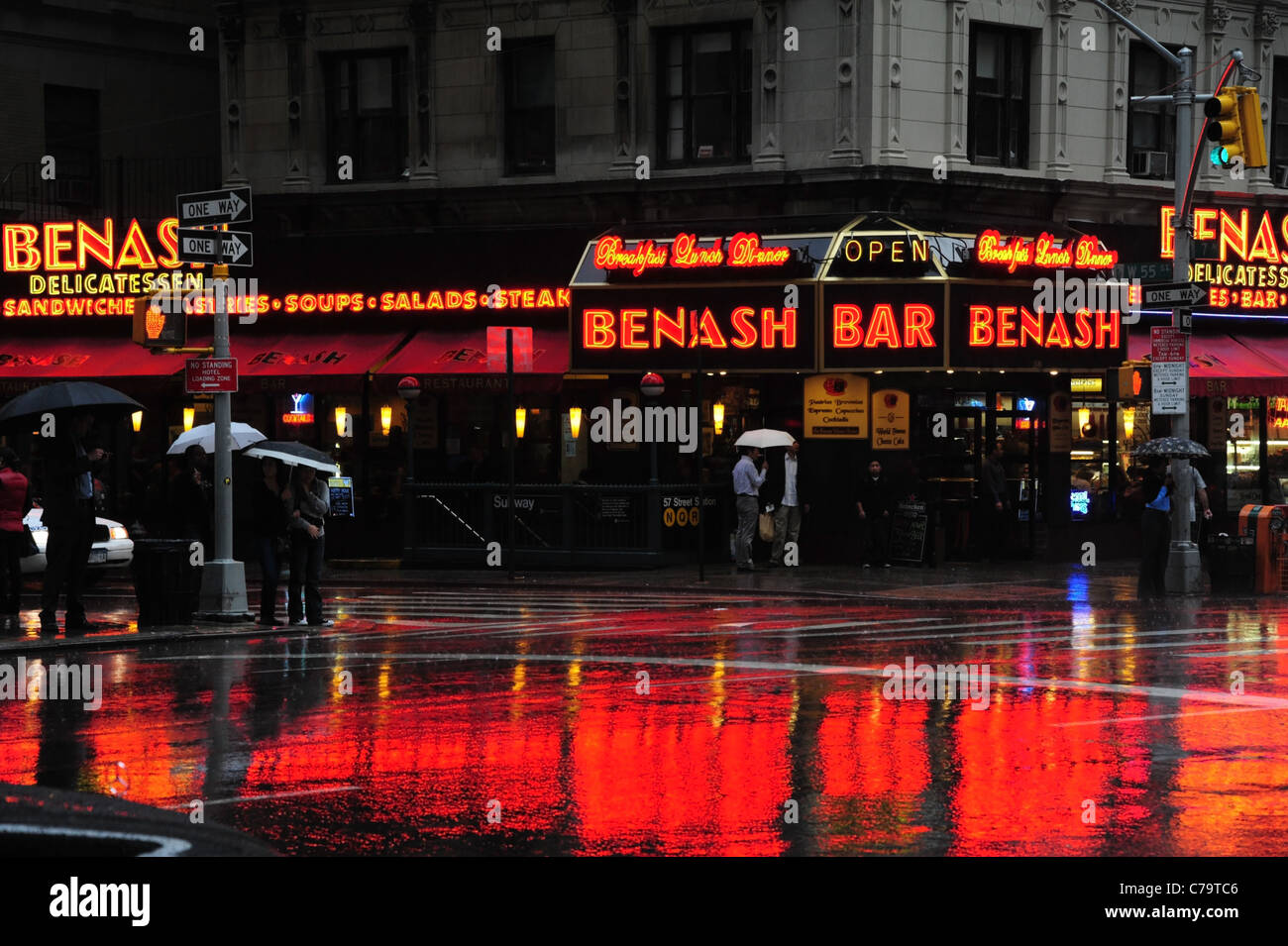 Rainy street view of red neon Benash Steak Bar signs reflecting on wet ...