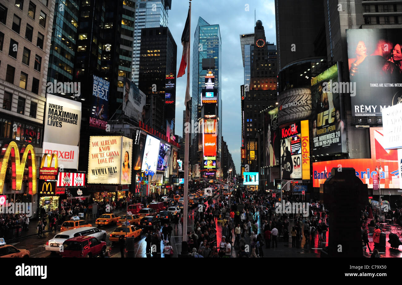 Evening twilight view of rain-reflection neon signs, people, traffic ...