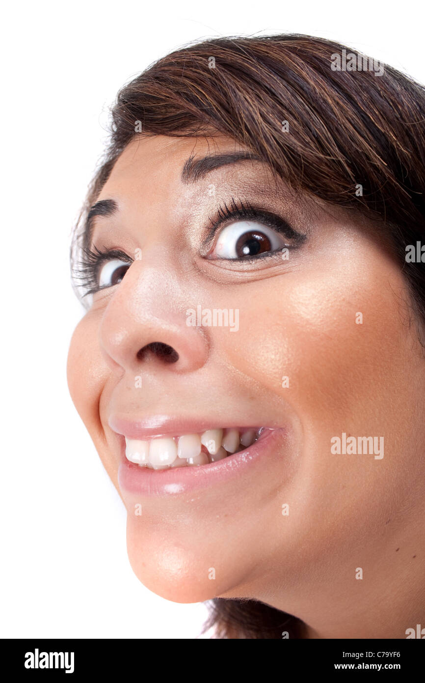 Woman with a funny look on her face smiles over a white background ...