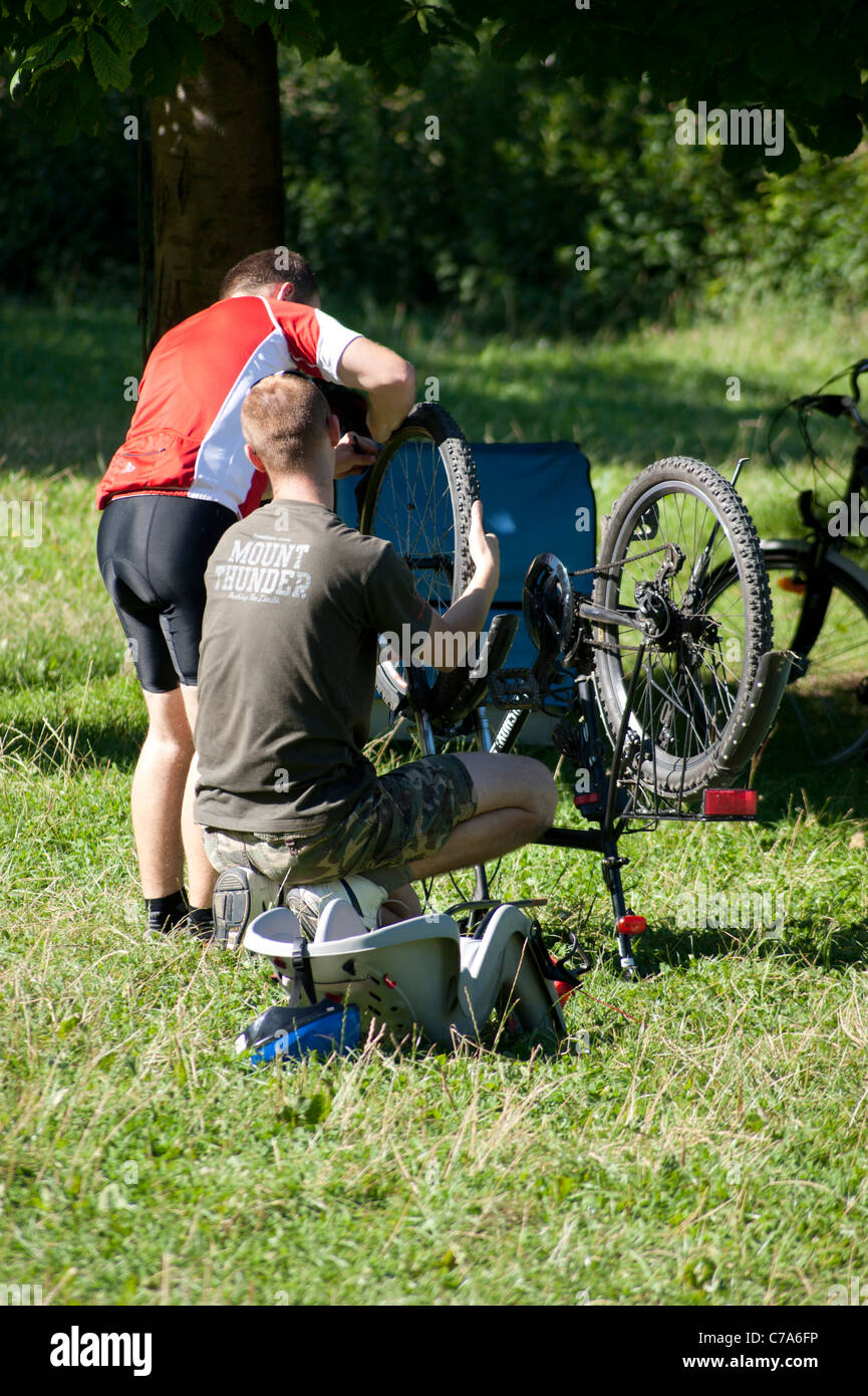 Two men repairs circle in cycle Stock Photo - Alamy