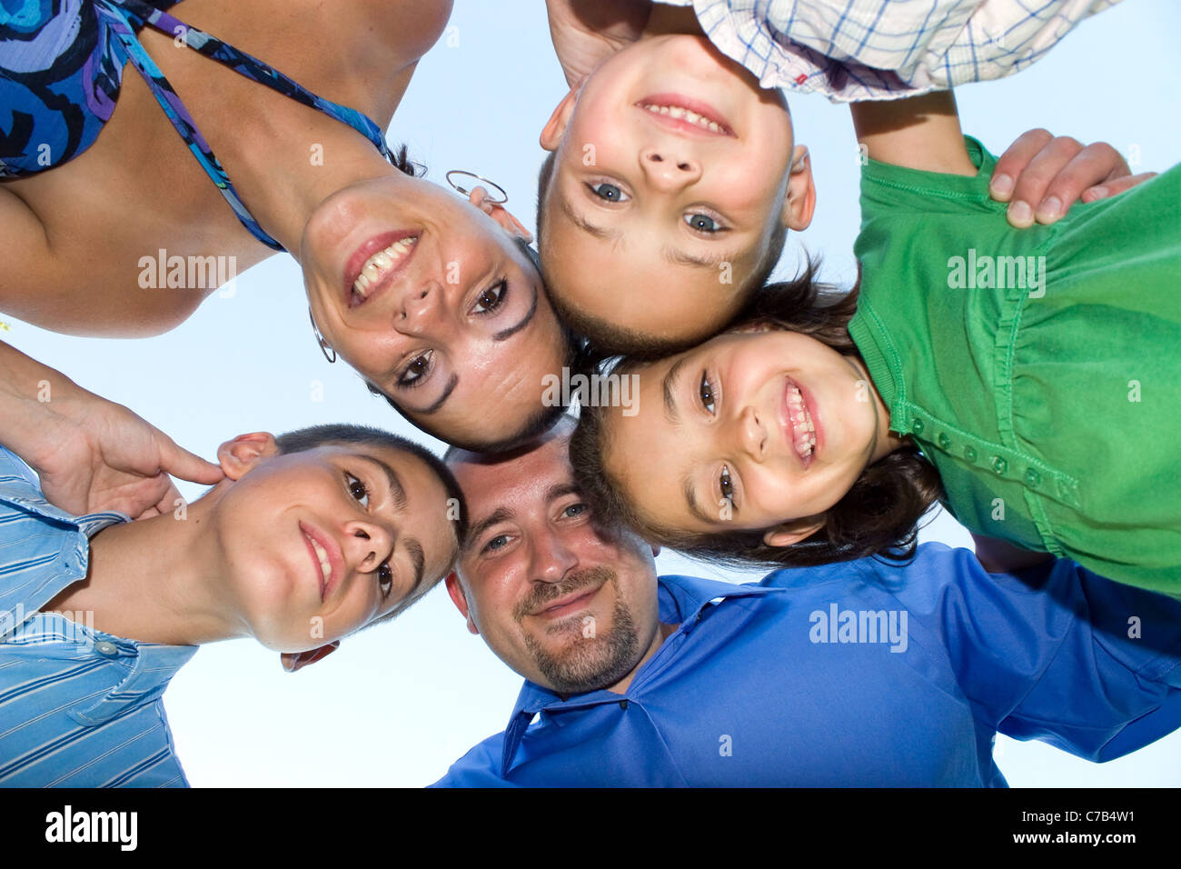 A happy family posing in a group huddle formation. Shallow depth of ...