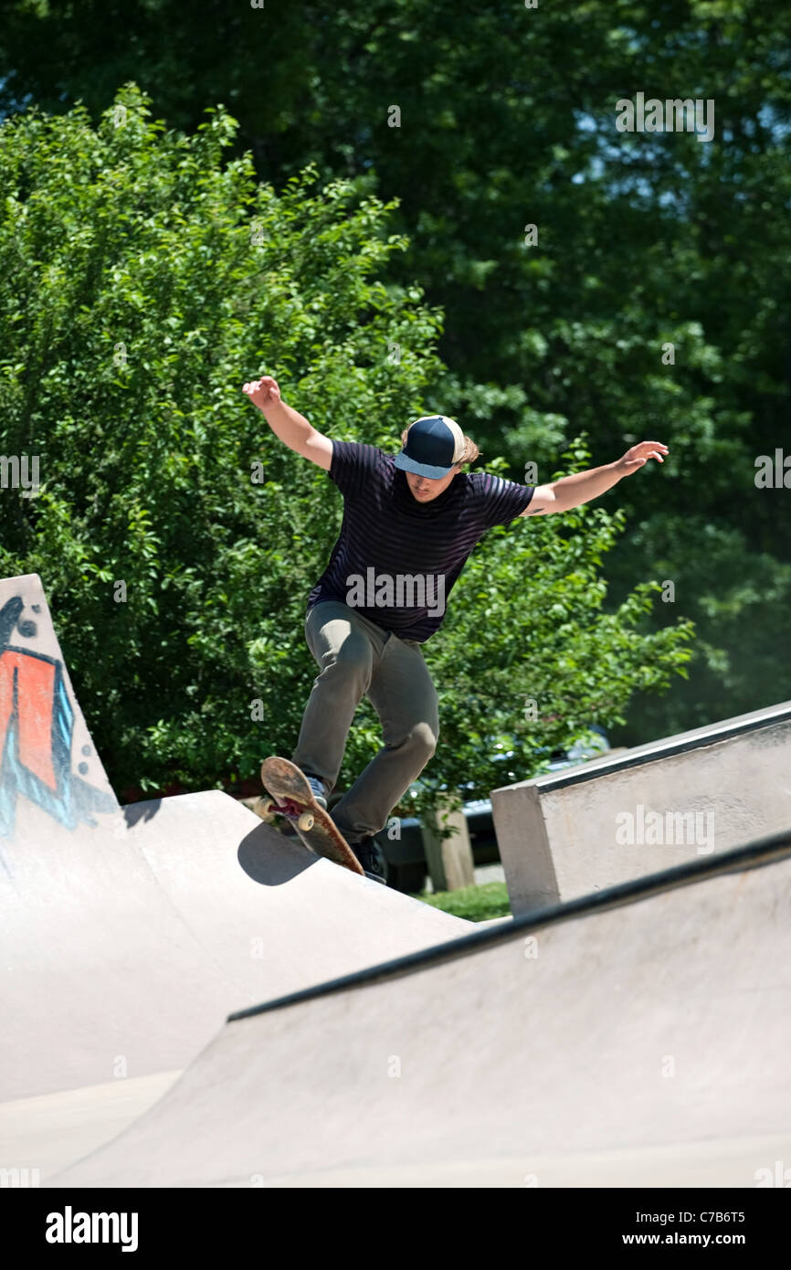 Action shot of a skateboarder going up a concrete skateboarding ramp at ...