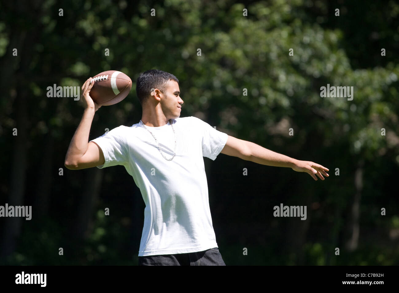 A young man throwing a football outdoors Stock Photo - Alamy