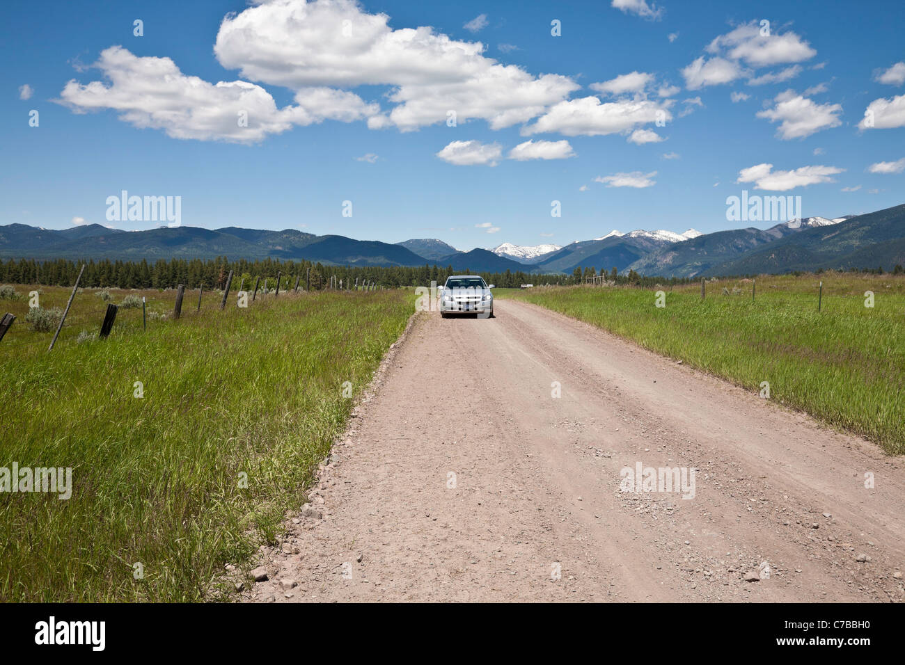 Automobile driving on an unpaved road in the Rocky Mountains of Montana ...