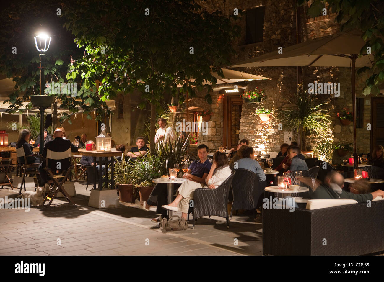 People enjoying a drink at an outdoor bar at night, Grado, Friuli ...