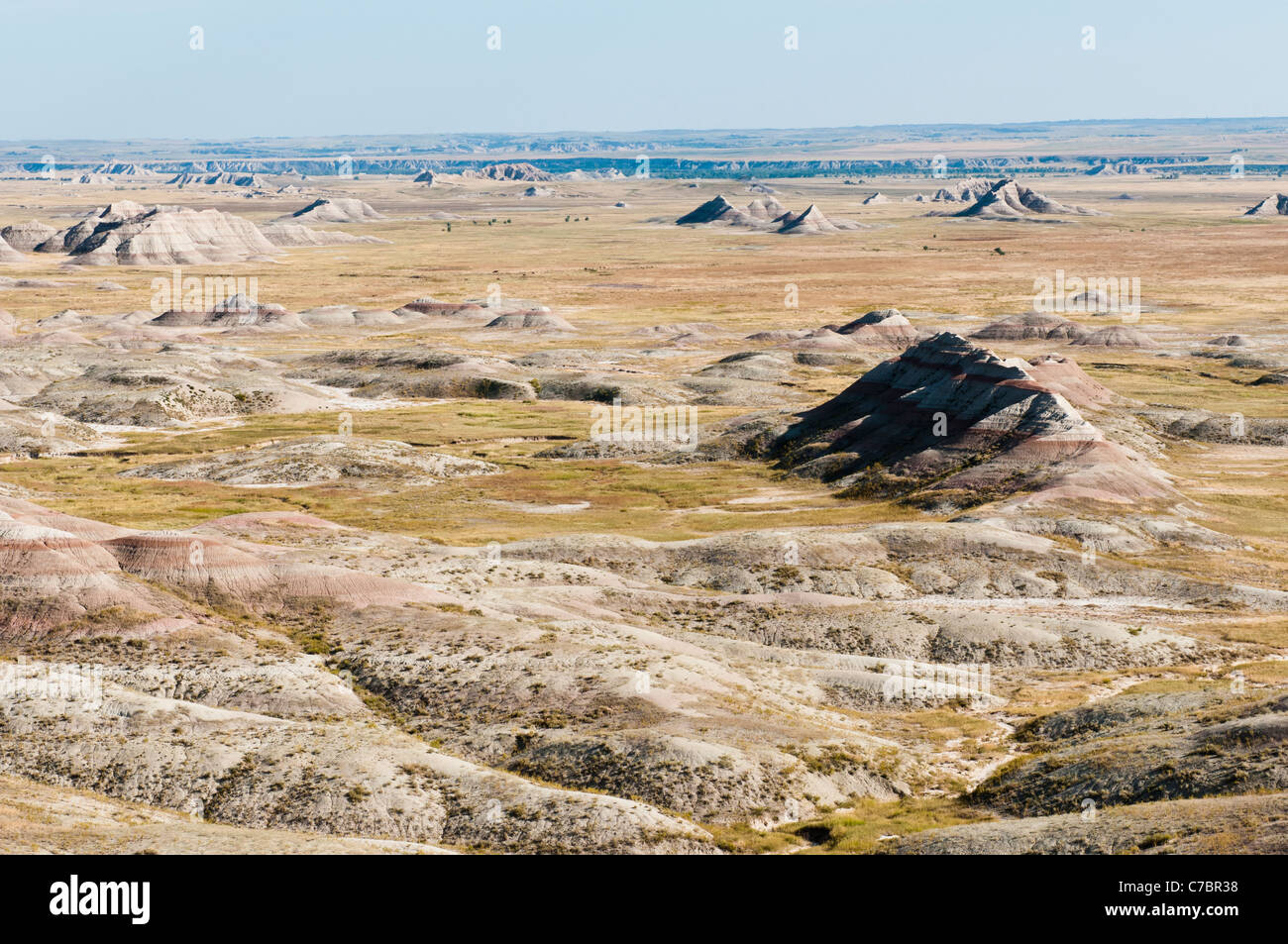 Sculpted buttes and spires rise above prairie grasslands in Badlands ...
