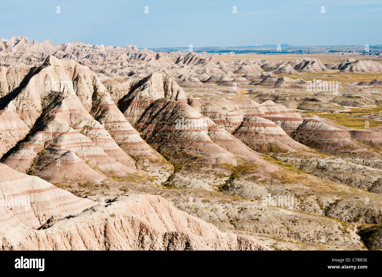 Sculpted buttes and spires rise above prairie grasslands in Badlands ...