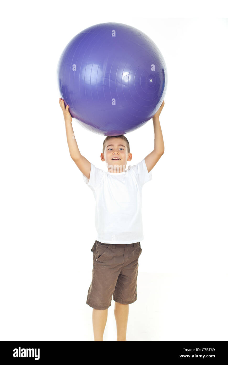 Boy holding big mauve ball over his head isolated on white background ...