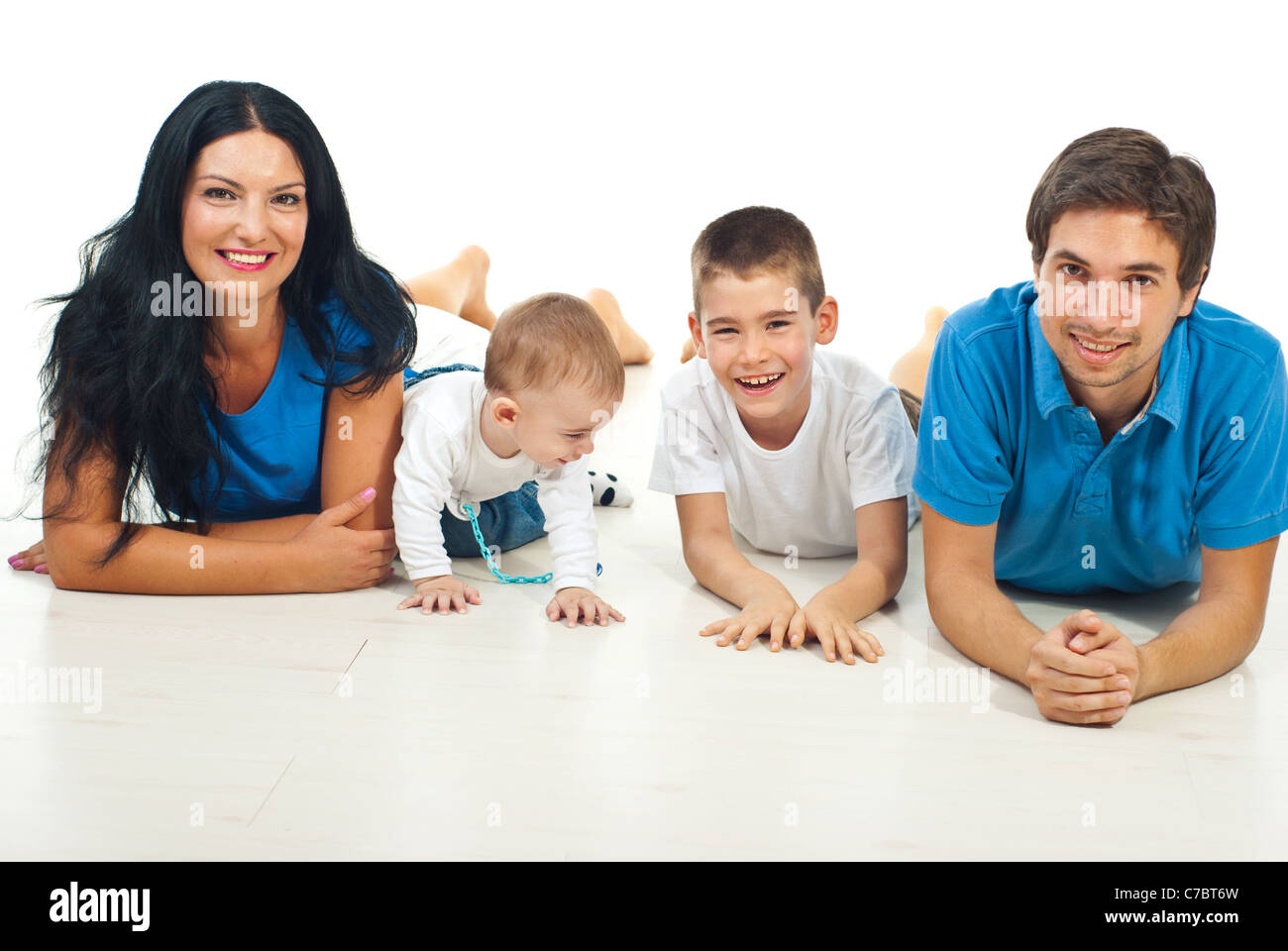 Happy family of four members lying on floor together and smiling ...