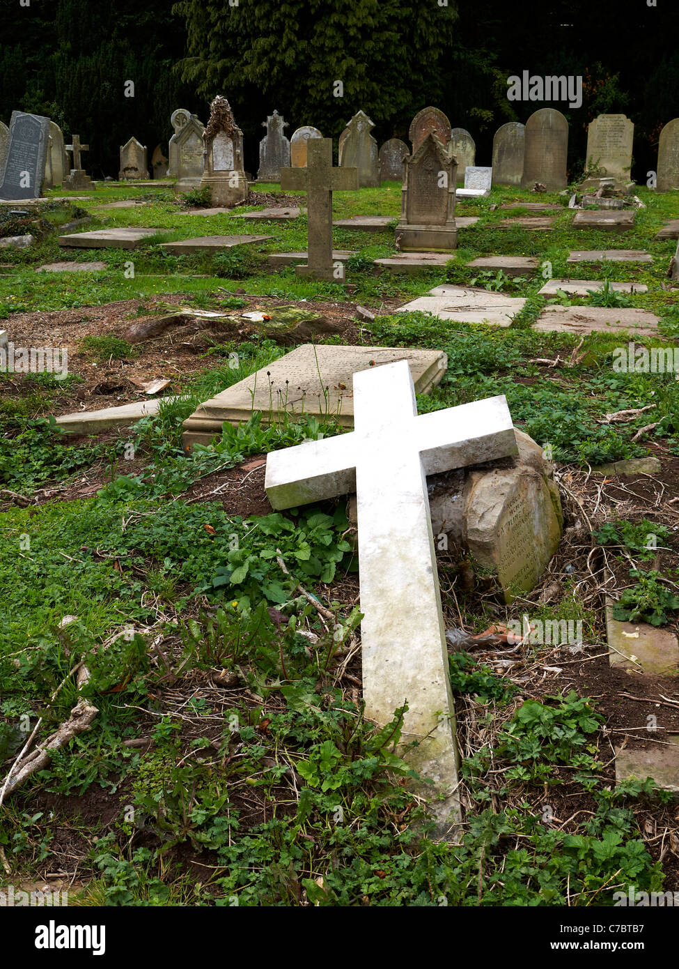 Fallen cross in graveyard uk Stock Photo - Alamy