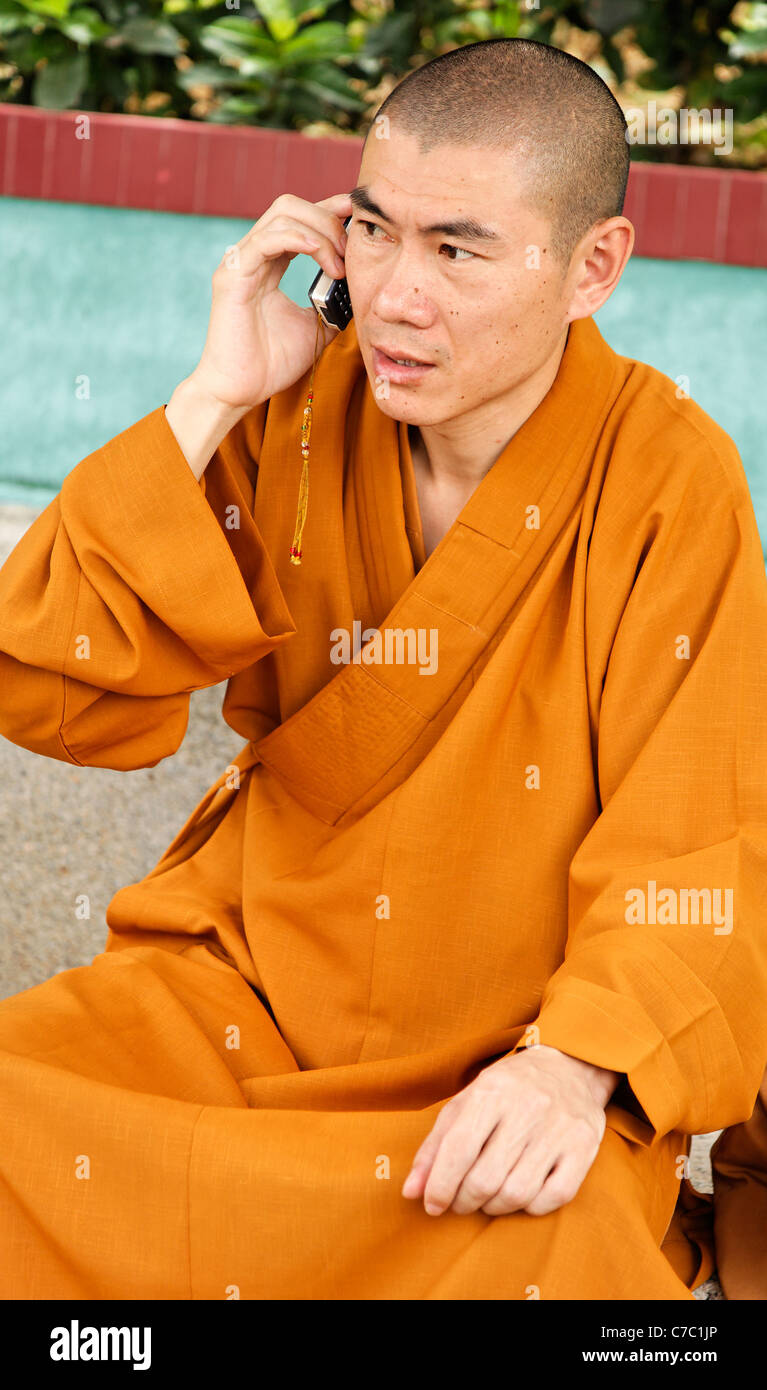 Buddhist monk on cell phone at Po Fook Hill Cemetery, Sha Tin, New ...