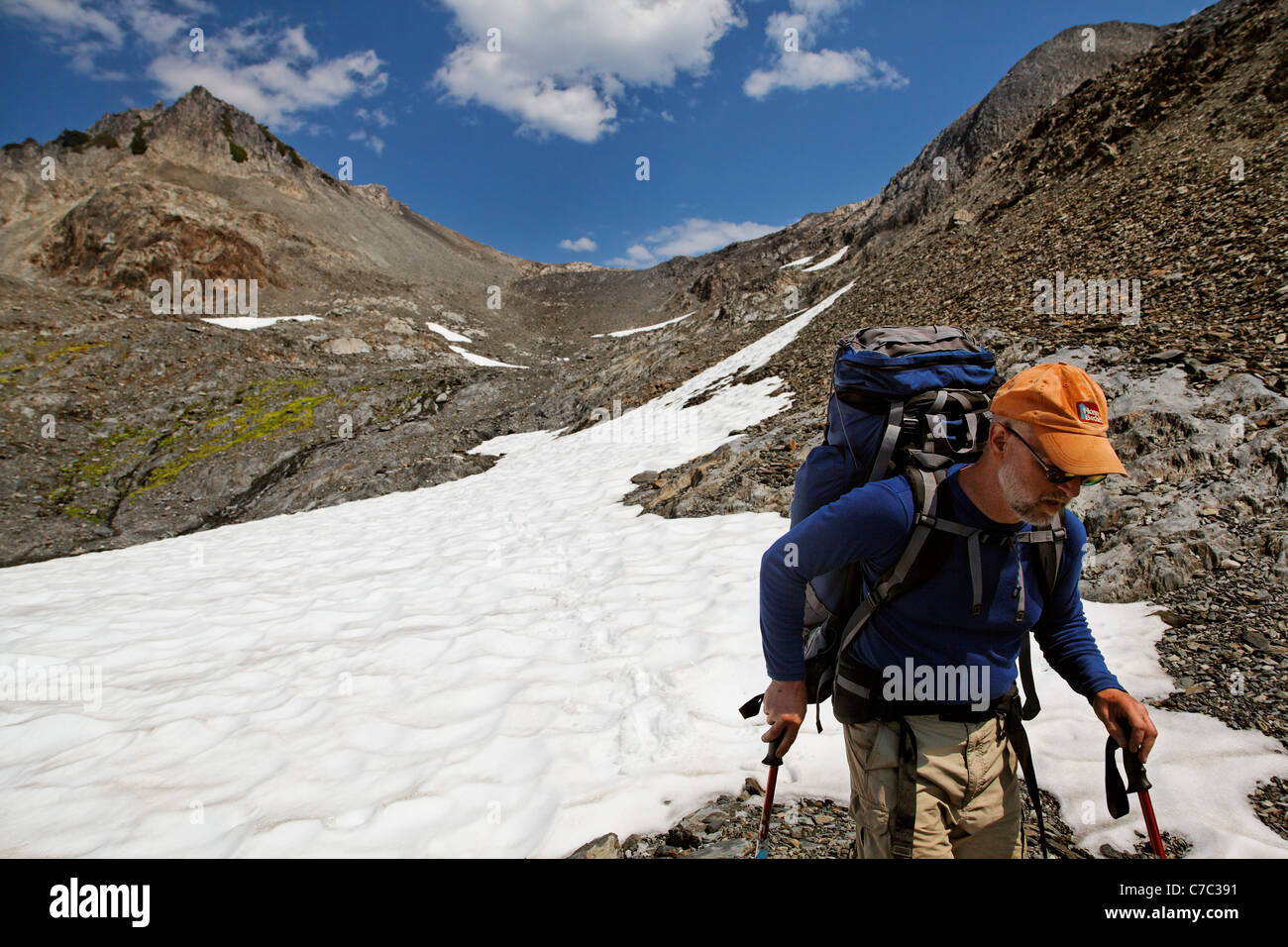 Backpacker climbing snow slope, Bailey Range Traverse, Olympic ...