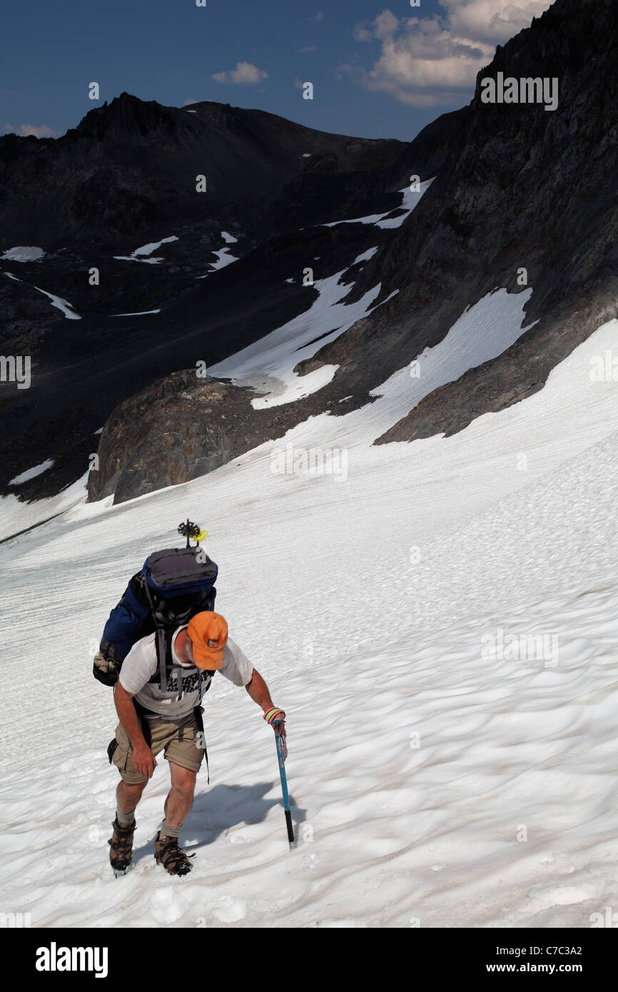 Backpacker climbing snow slope, Bailey Range Traverse, Olympic ...