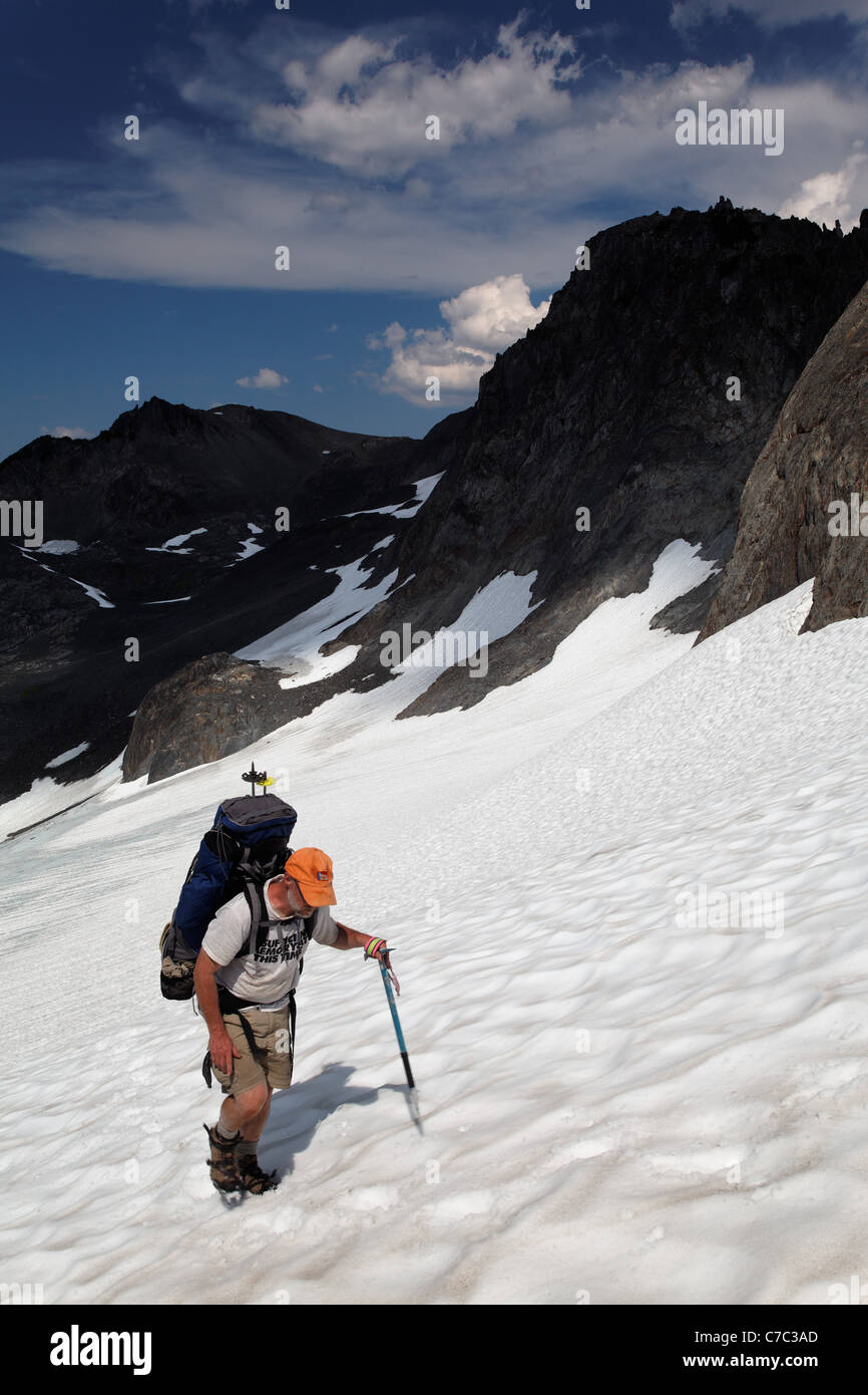 Backpacker climbing snow slope, Bailey Range Traverse, Olympic ...