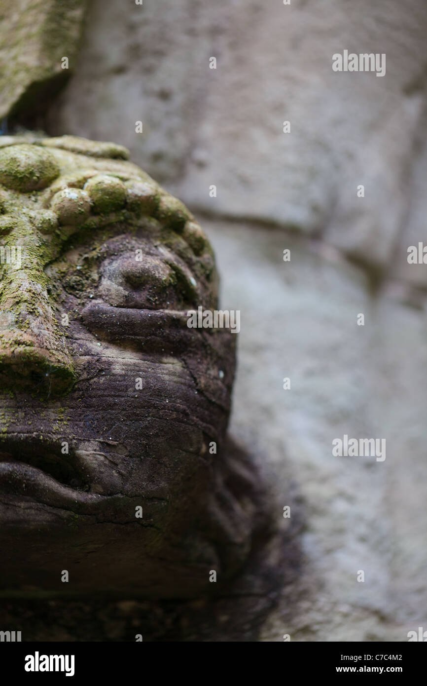 Half of a worn, ugly gargoyle face Stock Photo - Alamy