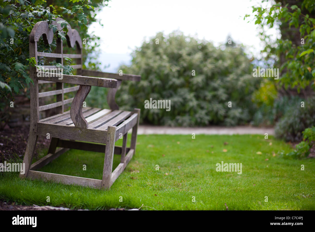 A wooden bench on uneven grass Stock Photo - Alamy