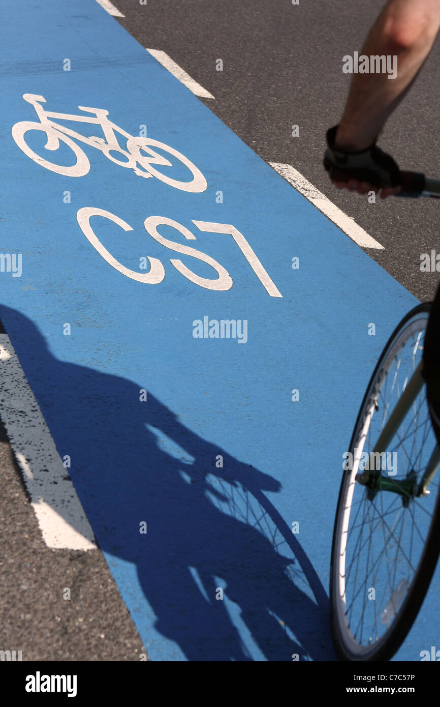 Part of a cyclist and his shadow as he cycles in a blue cycle ...