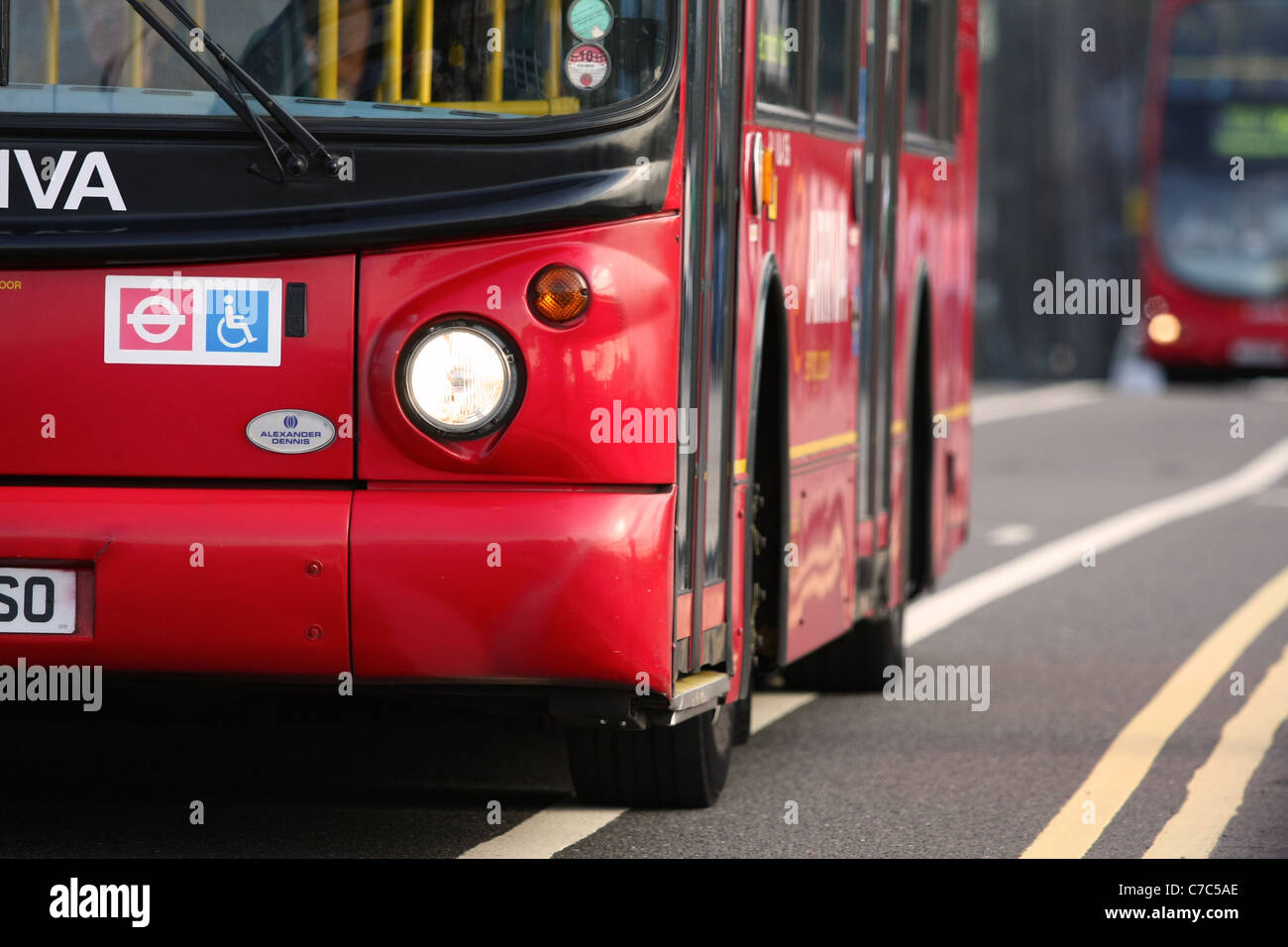 The lower part of a London bus as it travels along a road Stock Photo ...