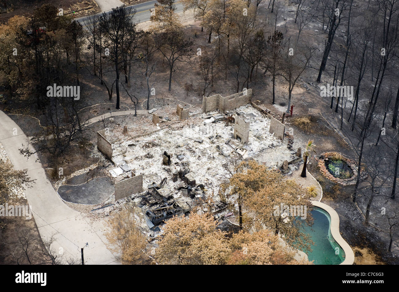 Aerial shows wildfire damage to the forest and a destroyed home in a ...