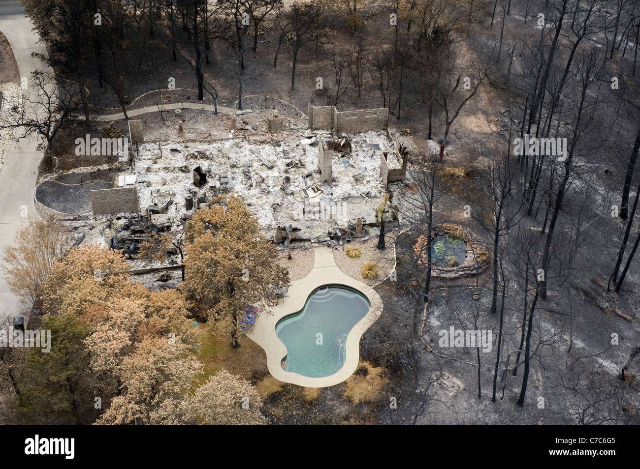 Aerial shows wildfire damage to the forest and a destroyed home in a ...