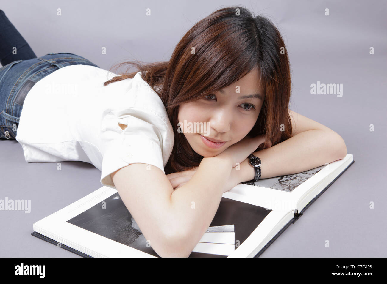 Girl lies on a heavy book Stock Photo - Alamy
