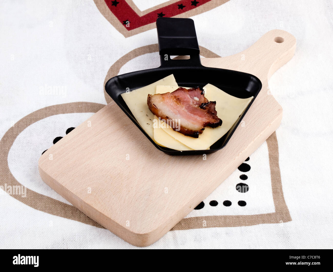 Raclette pan with cheese and tasty bacon Stock Photo - Alamy